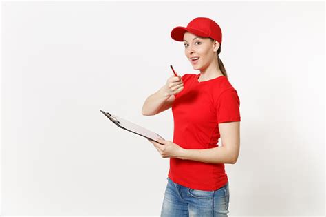 흰색 배경에 고립 된 빨간 유니폼에 배달 여자 택배 또는 딜러로 일하고 펜 종이 문서 빈 빈 시트와 클립보드를 들고 모자 티셔츠 청바지에 여성 공간에 복사 합니다 고용과