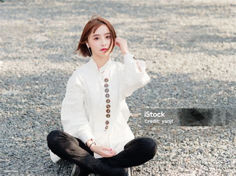 흰색 셔츠에 아름 다운 젊은 갈색 머리 여자 앉아서 화창한 날에 음악을 즐길 수 있습니다 매력적인 중국 쾌활 한 세련 된 여자의 야외 패션 초상화 감정 사람 아름다움과