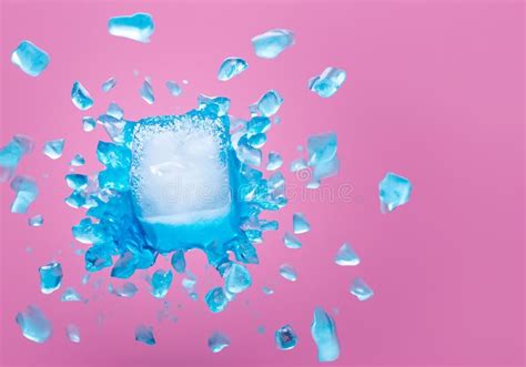 blue ice block exploding into shards on pink pastel background stock