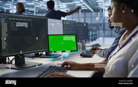 it experts using green screen tablet working together in server farm to optimize it for data