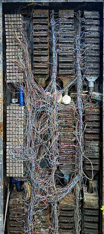 一个古老的盒子，老式的模拟拨号电话交换机，有很多凌乱的电线