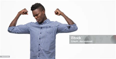 팔 근육 자랑 미소를 보여주는 블루 셔츠를 입고 젊은 아프리카계 미국인 남자 피트 니스 개념입니다 개념에 대한 스톡 사진 및 기타 이미지 Istock