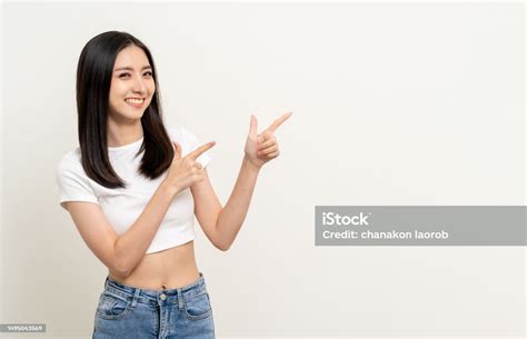 하얀 셔츠를 입은 행복한 아름 다운 아시아 여자가 손가락으로 공간을 복사한다 빈 공간을 가진 웃는 여성 아가씨 아시아의 귀여운 예쁜 사람들이 복사 공간 텍스트 광고를 찾고
