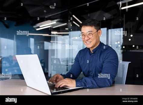 cheerful and smiling asian man working inside office businessman in