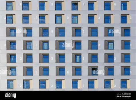 Facade With Pattern With Various Size Of Square Opening Rectangular Windows With Reflection
