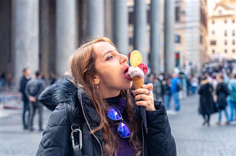 검은 머리를 한 재킷을 입은 젊은 행복한 라틴 여성 관광객이 이탈리아 로마의 판테온 앞에서 맛있는 아이스크림 콘을 즐기고 먹고 있다 35 39세에 대한 스톡 사진 및 기타