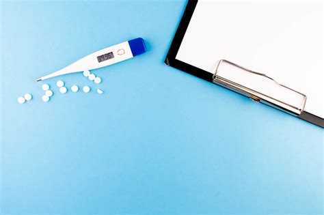 의료 장비 디지털 온도계 흰색 알약 및 텍스트 장소가있는 파란색 배경의 노트북 의료 템플릿 또는 모형 0명에 대한 스톡 사진 및