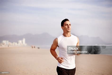 남자 모래 및 달리기 선수는 피트니스 야외 유산소 운동 및 운동을위한 스포츠 운동을위한 해변에서 남성 사람 물 및 운동 선수는 자연 바다 및 열대 휴일에 마라톤 훈련을 위해