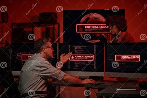 Mature Programmer Discussing Technical Problem With Female Colleague