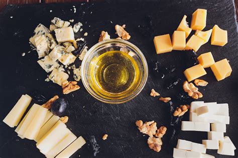 둥근 나무 보드 플레이트 Camembert 치즈에 모듬 치즈 오크의 치즈 강판 껍질 하드 치즈 조각 호두 포도 크래커 빵 백리향 어두운 검은 나무 배경 상단보기 0명에 대한