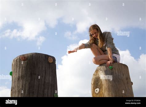 Girl Balancing On Tree Trunk Attempting Reach Across A Divide Stock Photo Alamy