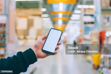 모형 기술 남자는 배경 슈퍼마켓에 자신의 손에 스마트 폰을 들고 남자에 대한 스톡 사진 및 기타 이미지 남자 모던 양식 무선 기술 Istock