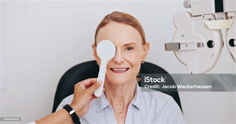 손 검안 및 건강 관리를위한 시력 검사에서 여성의 초상화 클리닉에서 폐색이있는 미소 및 성숙한 사람 안과 의사 얼굴 및 환자는 시력 검사 덮개 또는 교정을 위한 검사를