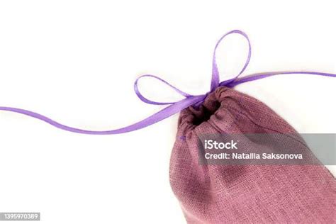 리본으로 묶인 보라색 린넨 파우치 작은 물건을 보관하기위한 가방 말린 허브 향기로운 가방 인테리어 세부 사항 선물 흰색 배경에 고립되어 있습니다 공간을 복사합니다