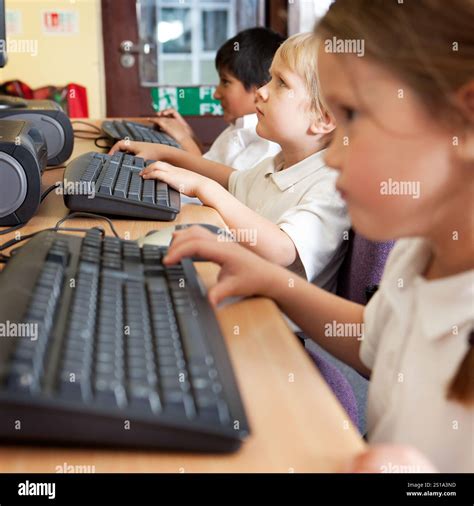 Elementary School Computer Lab A Small Group Of Primary Age Pupils Making Use Of Their School