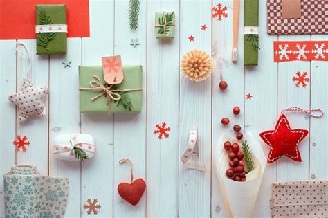 다양한 크리스마스 또는 새해 겨울 휴가 환경 친화적 인 장식 공예 종이 패키지 및 수제 또는 제로 폐기물 선물 흰색 나무 판자 녹색 잎과 수제 장식에 평면 누워 0명에 대한