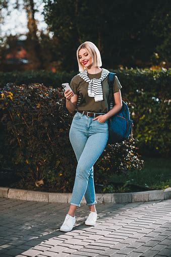 전체 크기 젊은 금발 소녀 홀드 장치 착용 카키색 옷 묶인 어깨 스웨터 산책 공원 화창한 봄 날씨 외부의 수직 사진 20 24세에 대한 스톡 사진 및 기타 이미지 Istock