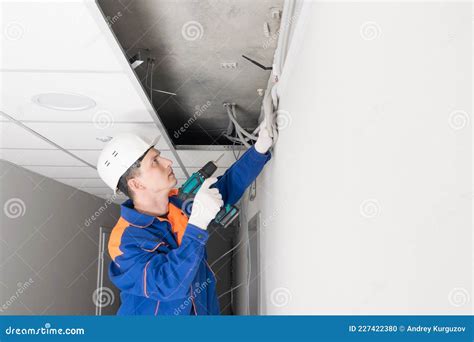 A Worker Installs A Router On The Wall To Transmit The Internet Signal In Offices And Homes