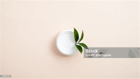 파스텔 베이지 색 배경에 흰색 유기농 화장품 크림과 녹색 잎 항아리 최소한의 평면 레이 스타일 구성 상단보기 스킨 케어 및 헬스케어 컨셉 0명에 대한 스톡 사진 및 기타