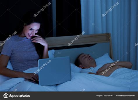 Woman Sitting Bed Night Using Laptop Computer While Husband Sleeping Stock Photo Nonhanon