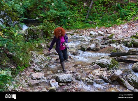 Redhead Woman With Curly Hair And Camera Hiking On A Trail In The