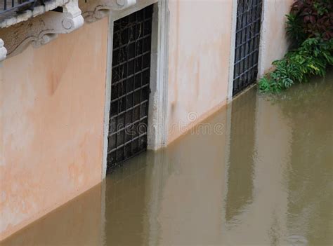 Wall And Windows Of The House Are Submerged By The Muddy River Water