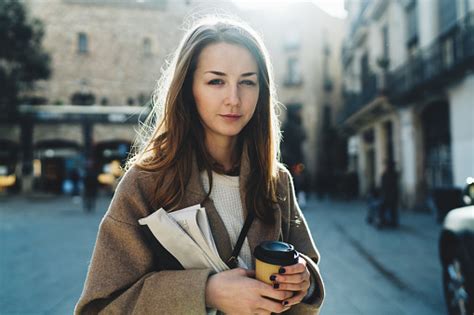 소식통 여자 걸릴 멀리 커피와 신문 야외 서 카메라 보고의 반 길이 초상화 화창한 아침에 사무실에가 긴 머리를 가진 백인 여성 신문에 대한 스톡 사진 및 기타 이미지