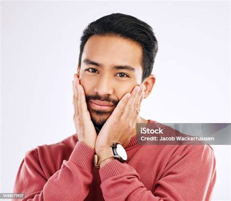 초상화 수줍음과 사랑에 빠진 스튜디오에서 그의 뺨을 만지면서 흰색 배경에 고립된 남자 얼굴 수줍고 귀여운 잘 생긴 젊은 인도 남성은 발렌타인 데이에 특별한 느낌을 받는다