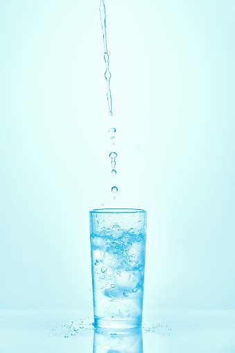 푸른 배경에 고립 된 얼음으로 유리에 물을 붓습니다 식탁에 물이 쏟아졌다 0명에 대한 스톡 사진 및 기타 이미지 0명 가득 찬 각얼음 Istock