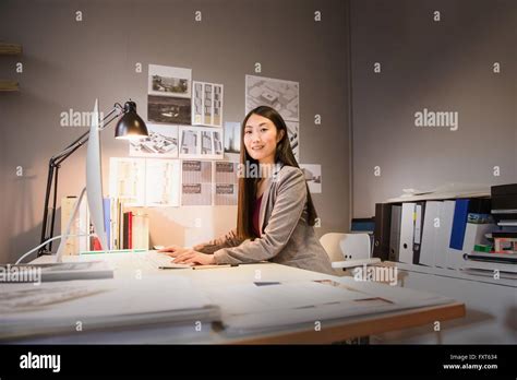 Side View Of Mid Adult Woman At Desk Using Computer Looking At Camera Smiling Stock Photo Alamy