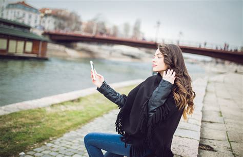 아름 다운 갈색 머리 소녀 시 강 옆에 앉아 휴대 전화를 사용 하 여 자유 시간을 즐길 하 고 Selfie 20 29세에 대한 스톡 사진 및 기타 이미지 Istock