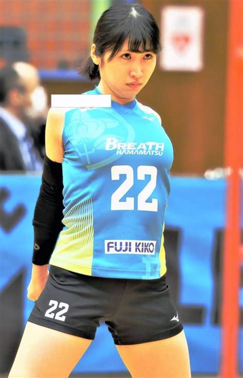 A Female Volleyball Player Standing On The Court With Her Leg In The Air And Looking At The Ball