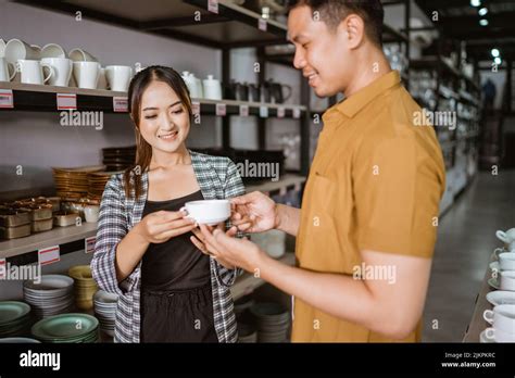 Beautiful Girl And Her Babefriend Holding Cups While Choosing Cups Stock Photo Alamy