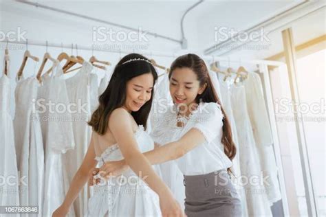 아시아 소녀 신부 웨딩 드레스 여자 디자이너 패션 스튜디오 행복 하 고 미소에 테이프를 측정 하 여 조정에 노력 하 고 2명에