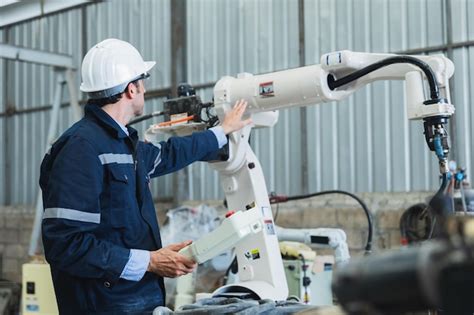 Premium Photo Engineer Controlling Robot Arm At Factory Checking The Operation Of Robot Arm