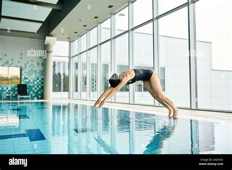 Elegant Young Woman In Black Swimsuit Gracefully Diving Into A Serene