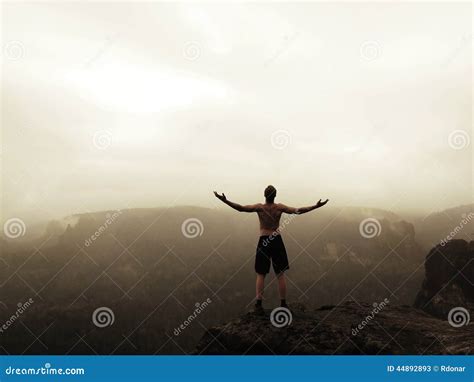 Climber In Black Pants Gesture Of Triumph Naked Tourist On The Peak Of Sandstone Rock Above