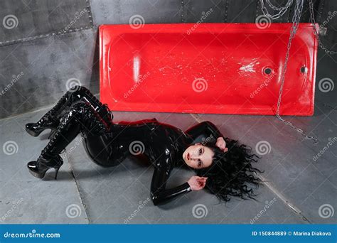 Fashionable Caucasian Brunette Girl Wearing Black Latex Catsuit And