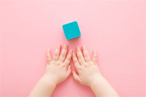 밝은 분홍색 테이블 배경에 밝은 파란색 플라스틱 모양을 가지고 노는 여자 아기 파스텔 색상 근접 촬영 유아 발달 장난감 시점 촬영 하향식 보기 개발에 대한 스톡 사진 및