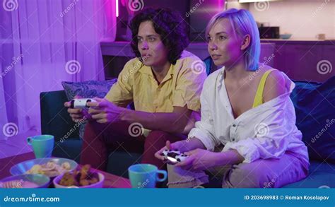 Novio Feliz Y Novia Jugando Videojuegos Y Cargando Joysticks En Casa La Pareja Milenaria