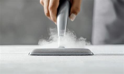 Using A Steam Cleaner A Woman Disinfects And Cleans A White Surface