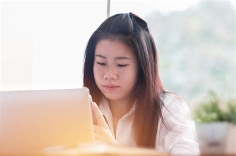 온라인 스마트폰 개념으로 소셜 네트워크 검색 아시아 귀여운 여자 쇼핑 또는 사무실 배경에서 그녀의 친구에 게 Sms 메시지를 입력 스마트폰 및 노트북 컴퓨터를 사용 하 여