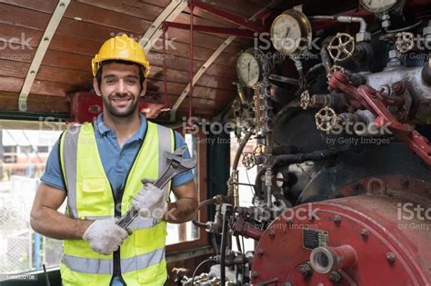 물 펌프장에 있는 남성 배관공 유지 보수 수도관의 초상화 남성 배관공 엔지니어는 직장에서 파이프를 수리하고 안전복 헬멧 장갑을