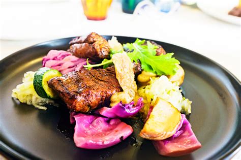 붉은 양배추 소금에 절인 양배추 호박 감자 및 잘게 썬 사과로 만든 소스를 곁들인 구운 돼지 고기 필레의 고급 레스토랑 식사 0