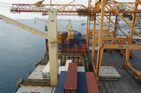 Container Vessel Equipped With Cranes During Cargo Operation Loading And Discharging By Yellow