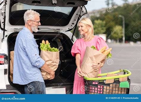 Seniors Loading Groceries To Car Trunk After Shopping Stock Image