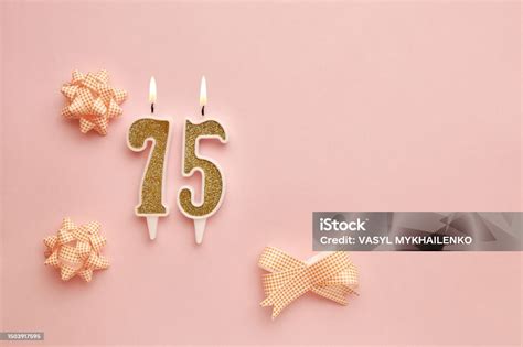 축제 장식이 있는 파스텔 핑크 배경에 숫자 75가 있는 양초 생일 축하 촛불 생일 기념일 중요한 날짜 휴일을 축하하는 개념입니다