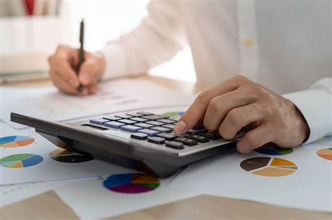 Premium Photo A Man Uses A Calculator To Calculate Company Profits