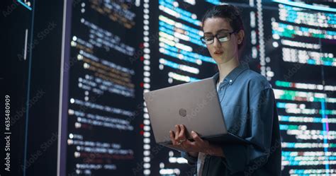 Portrait Of Woman Creating A Software And Coding Surrounded By Big Screens Displaying Lines Of