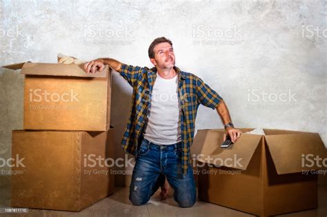 새로운 아파트 또는 쾌활 한 속성 소유자 상태를 축 하 하 웃는 집에 혼자 이동 하는 골 판지 상자를 풀고 즐기는 집 바닥에서 젊은 행복 하 고 흥분 남자 긍정적인 감정